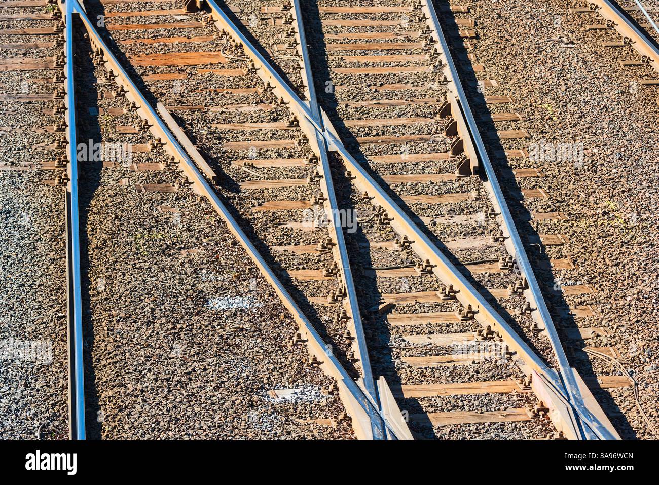 Visible railway tracks in Sweden show an intersection, with wooden ties ...