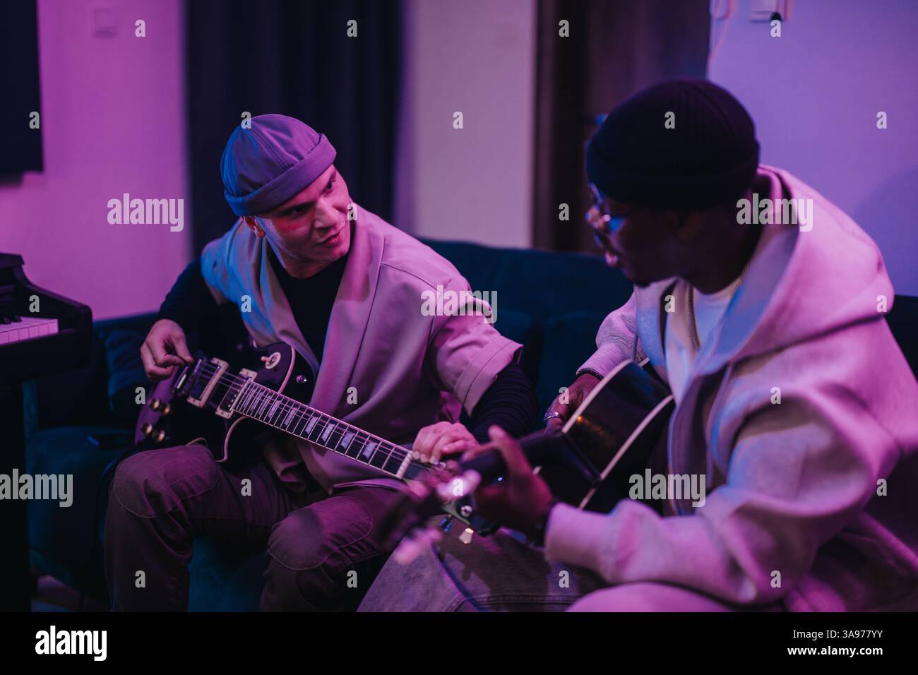 Multiracial musicians collaborate on guitar and piano in a creative ...