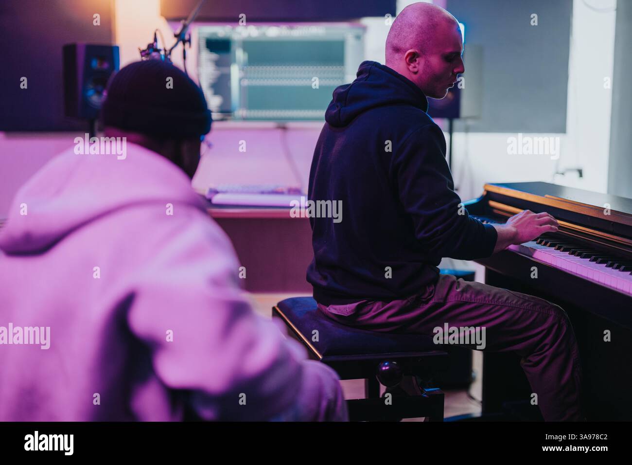 Two musicians collaborating in a modern recording studio with digital ...