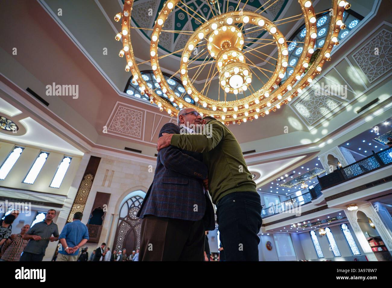 Dohuk, Iraq. 30th Mar, 2025. Iraqi Kurdish Muslims exchange greetings ...