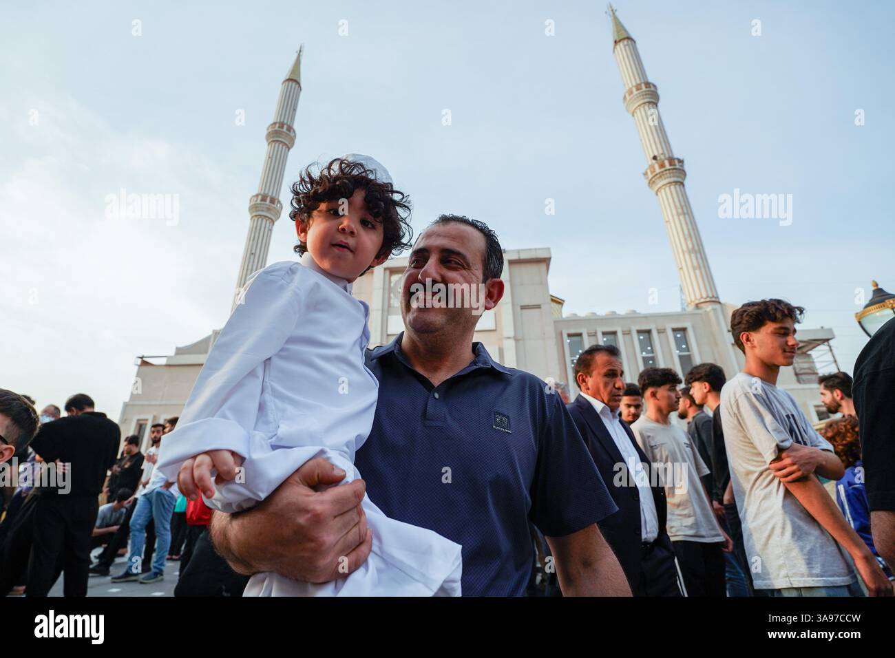 Dohuk, Iraq. 30th Mar, 2025. An Iraqi Kurdish man carries his son after ...