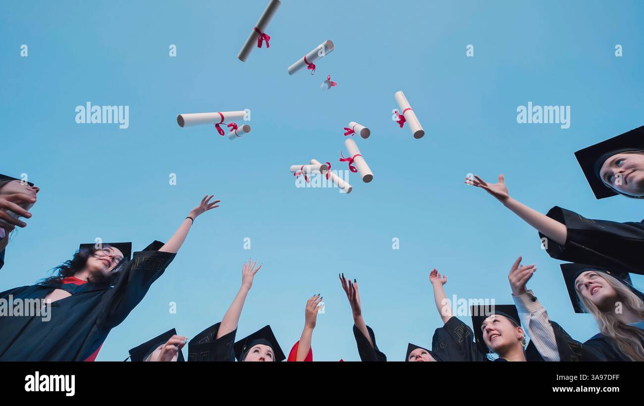 Cheerful graduates celebrating their academic success and the beginning ...