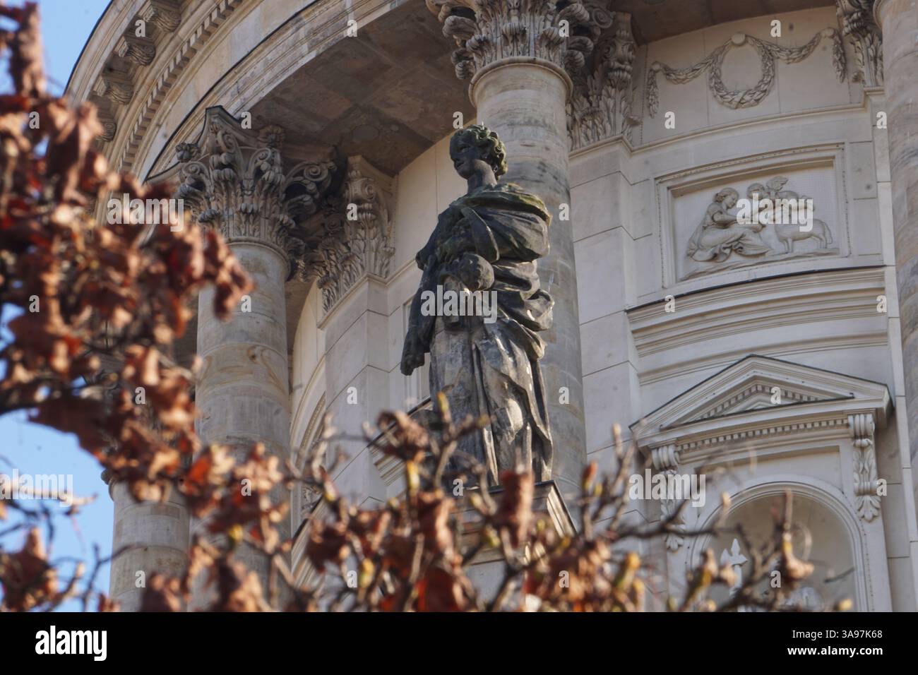 Red leaves of the trees frame the beautiful angel statue on the church ...