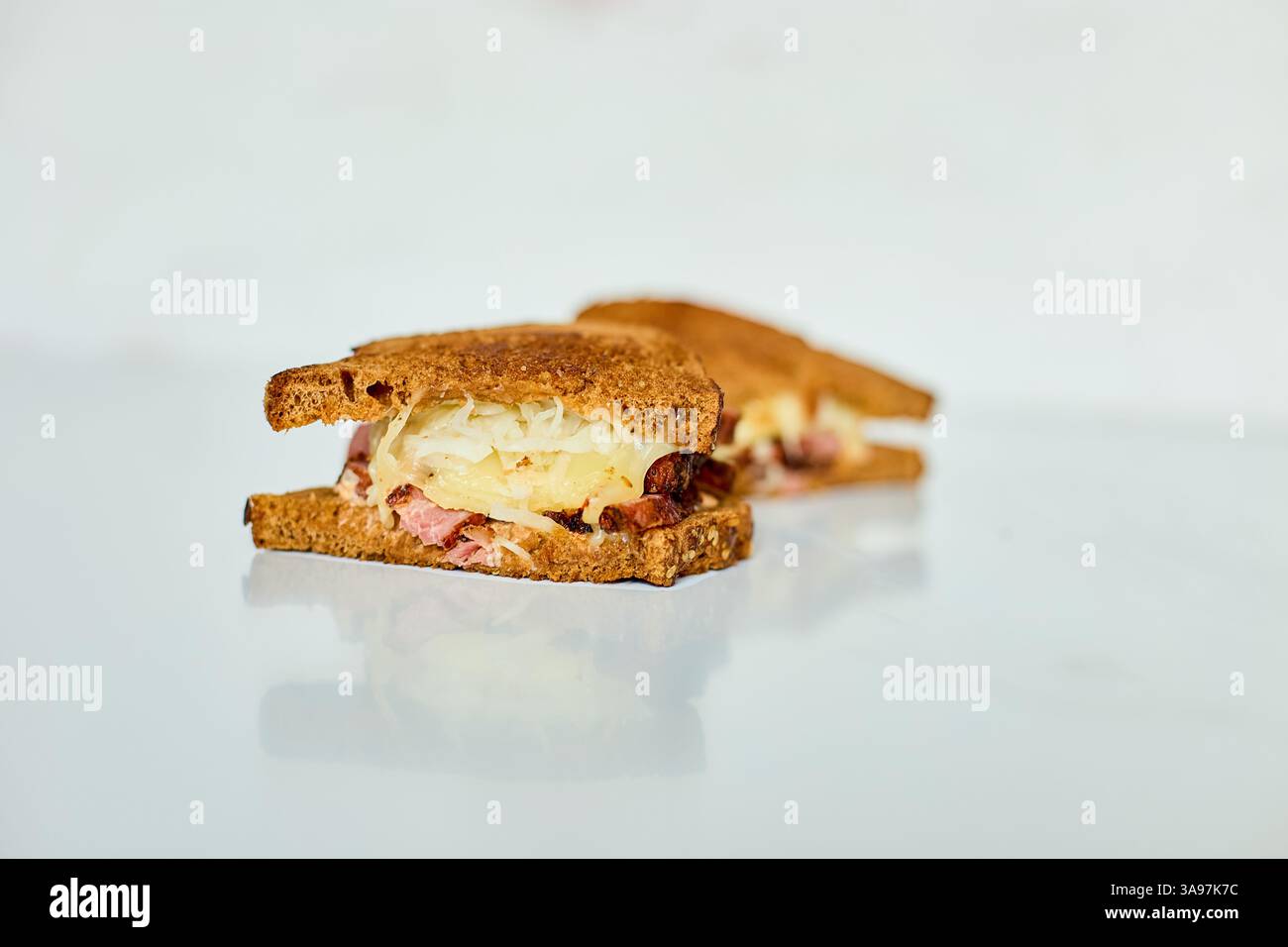 A Reuben sandwich showcases layers of corned beef, sauerkraut, and ...