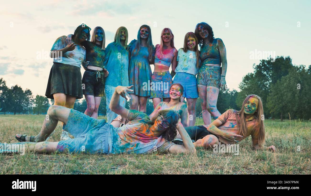 Friends covered in colored powder posing together at holi festival ...