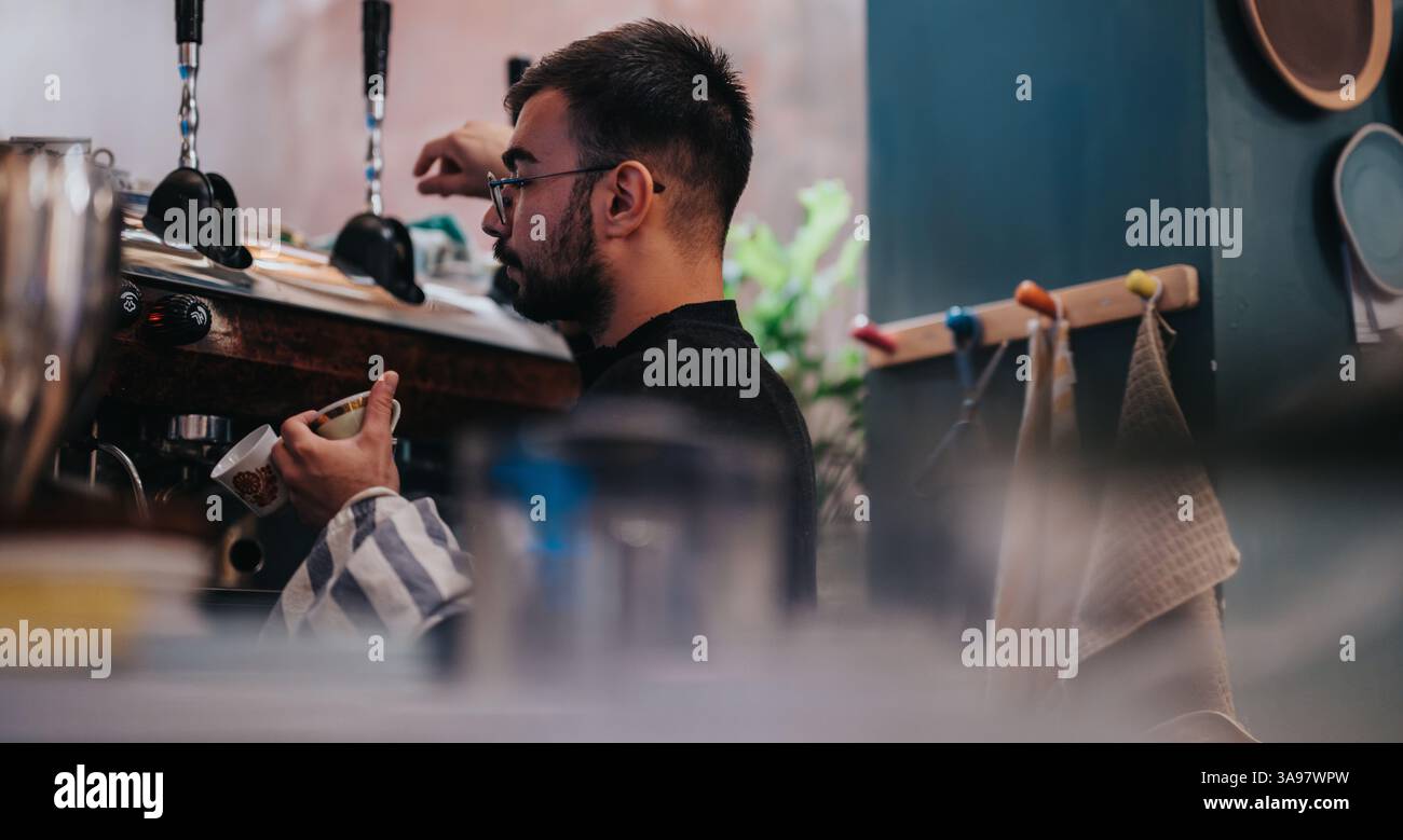 Barista preparing coffee while operating professional espresso machine ...