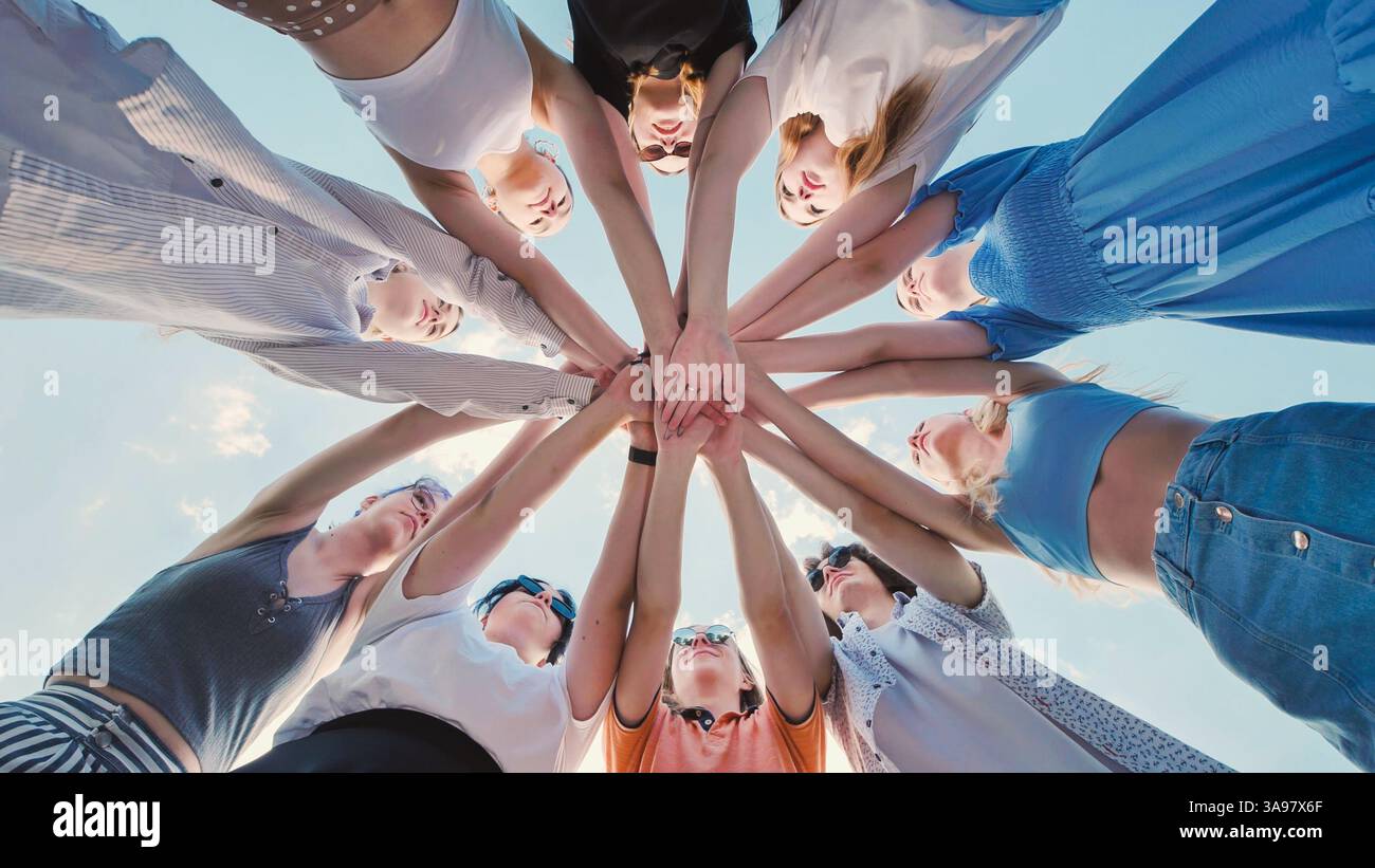 Group of school friends forming a circle, joining hands, symbolizing ...