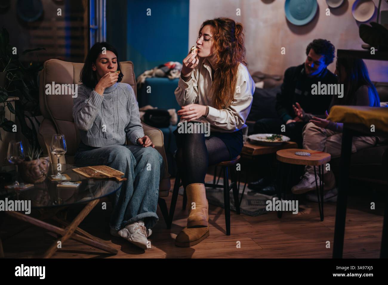 Friends enjoying food and relaxed conversations at a cozy evening ...