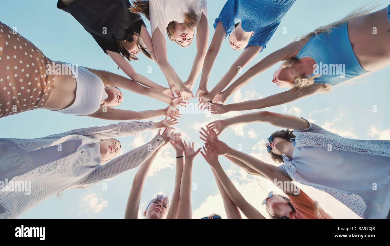 School friends joining hands in a circle, showing teamwork and unity ...