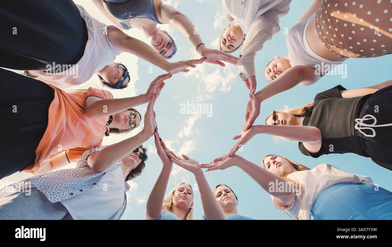 School friends coming together to form a united circle under a clear ...