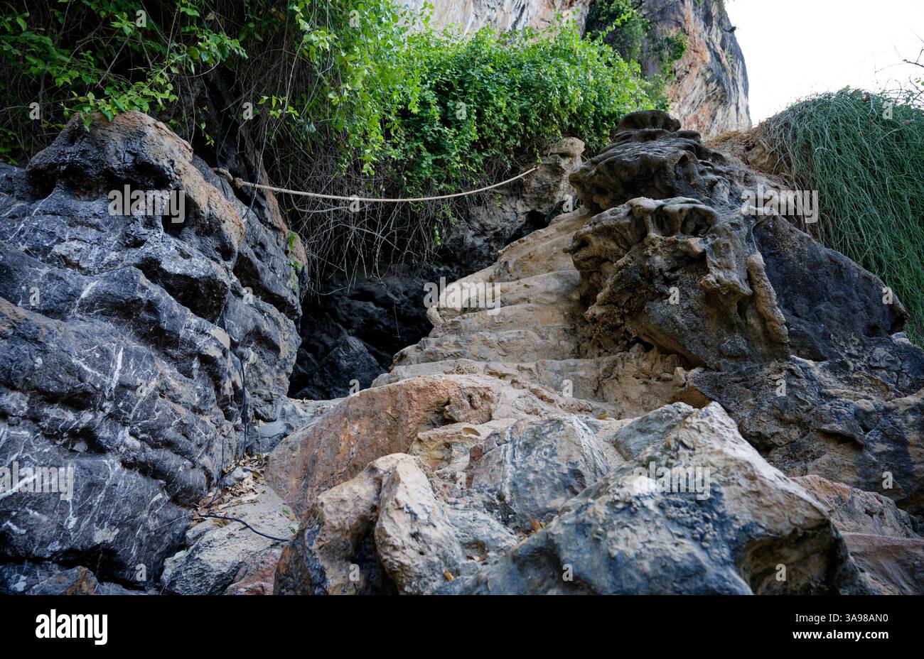 Rough limestone steps wind upward with a simple rope handrail guiding ...