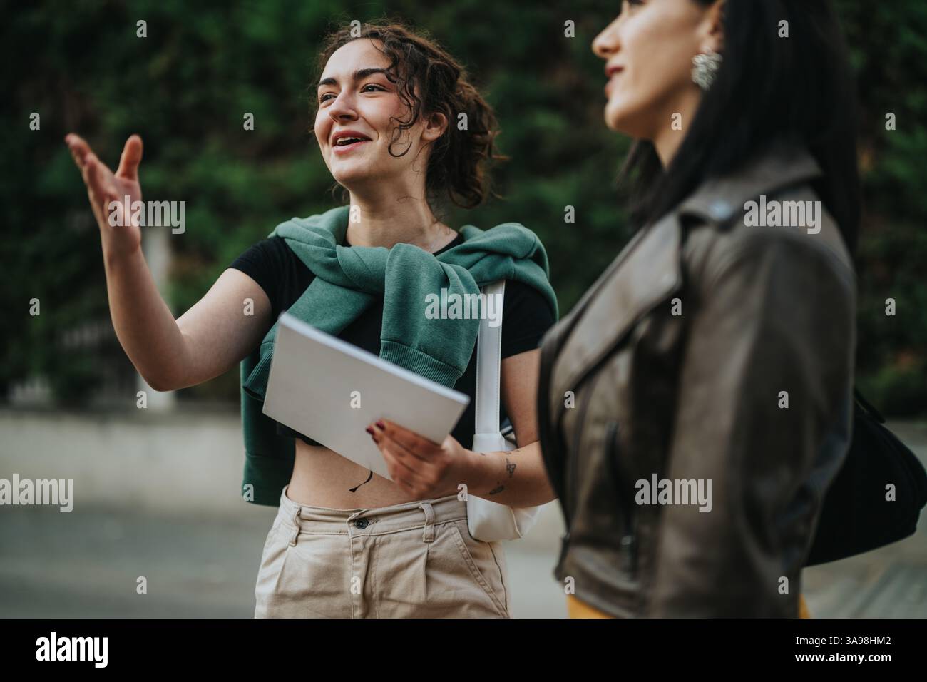 Two friends having a conversation outdoors in a casual and relaxed ...
