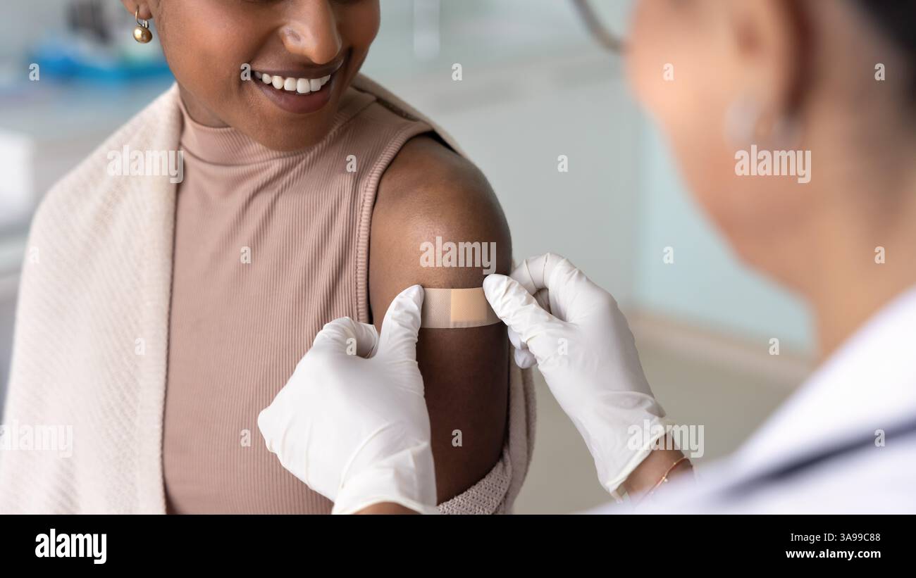 Female doctor sticking plaster on shoulder of patient Stock Photo - Alamy