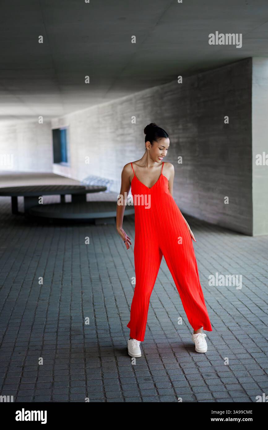 A Stylish Model Dressed in a Bright Red Jumpsuit Posing Gracefully in a ...