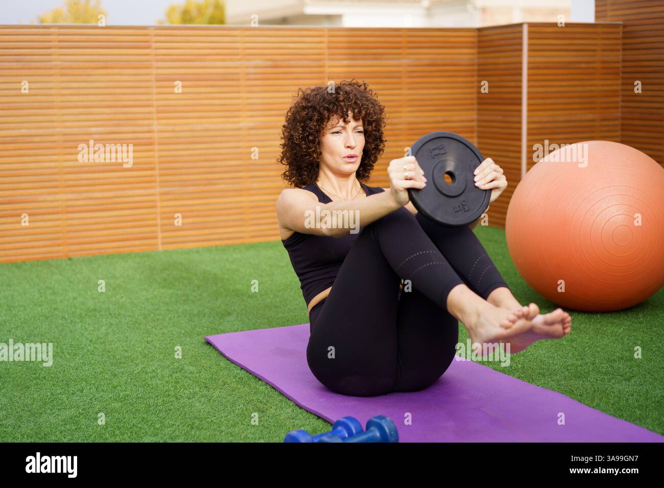 A dedicated fitness enthusiast is performing an intense core workout ...