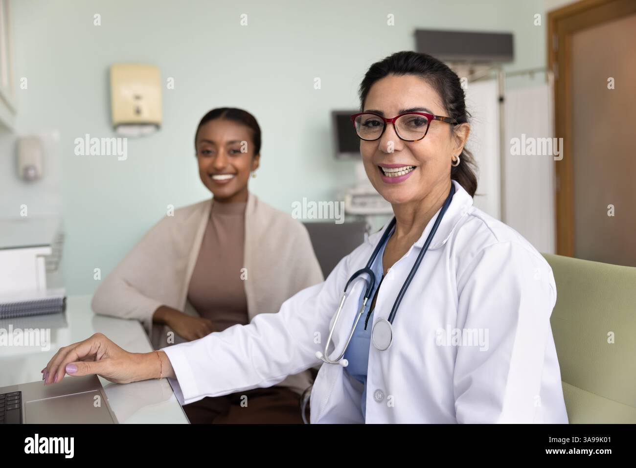 Happy senior Caucasian doctor woman meeting with young African patient ...