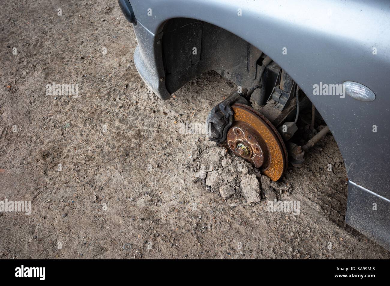 Rusty hub of an abandoned passenger car. Visible wheel arches of a gray ...