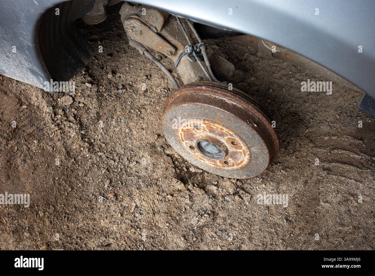 Rusty hub of an abandoned passenger car. Visible wheel arches of a gray ...