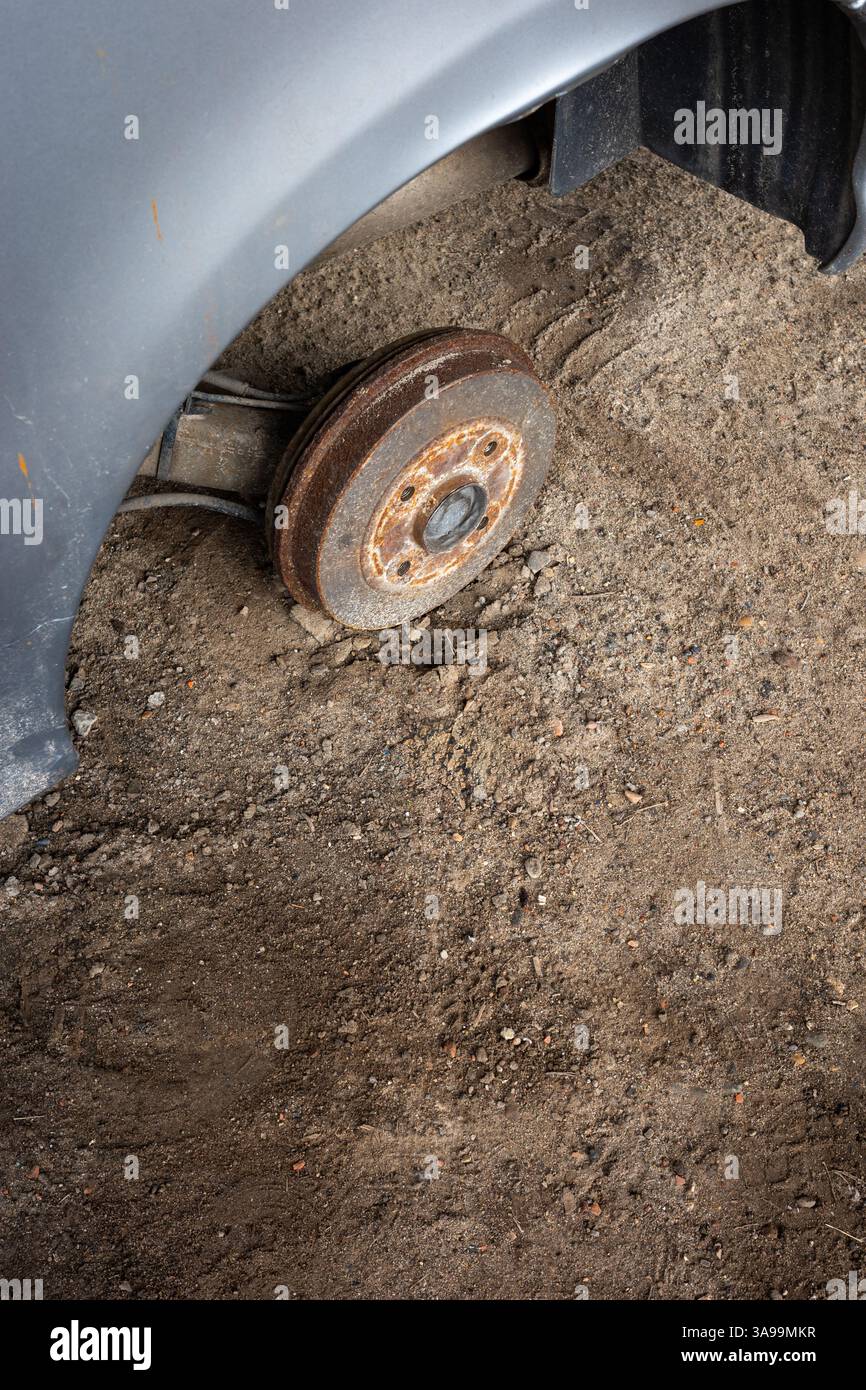 Rusty hub of an abandoned passenger car. Visible wheel arches of a gray ...