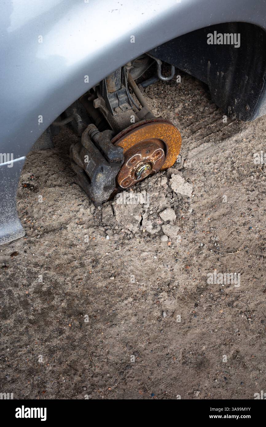Rusty hub of an abandoned passenger car. Visible wheel arches of a gray ...