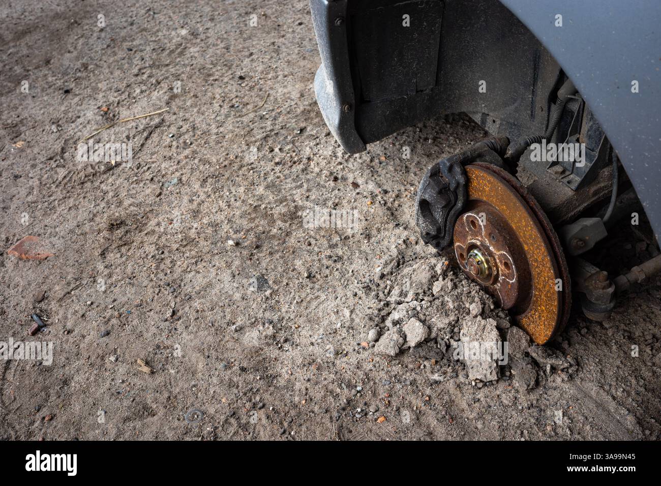 Rusty hub of an abandoned passenger car. Visible wheel arches of a gray ...