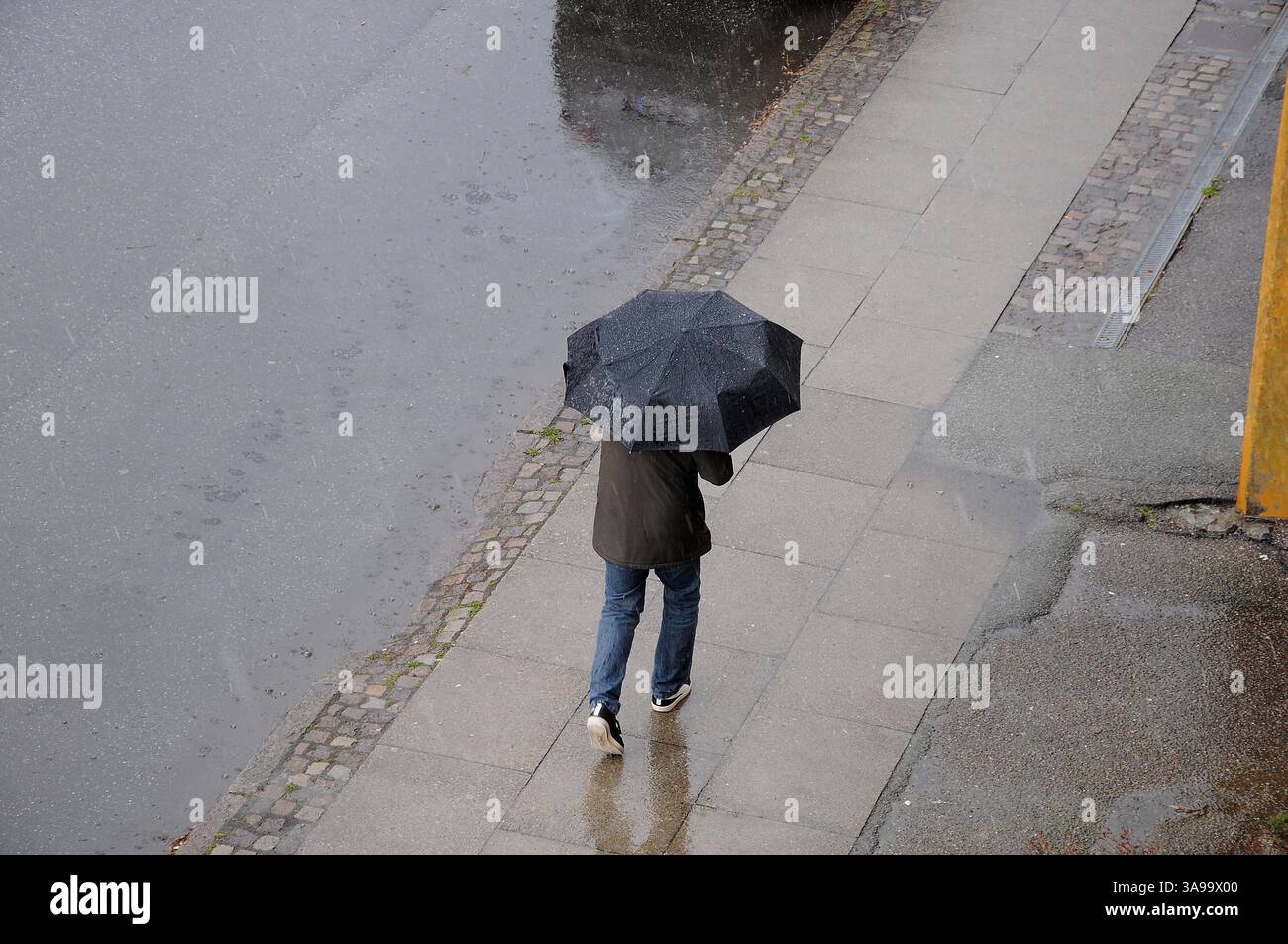 Copenhagen/ Denmark/30 march 2025/ Danish weather rain fall prson walk ...