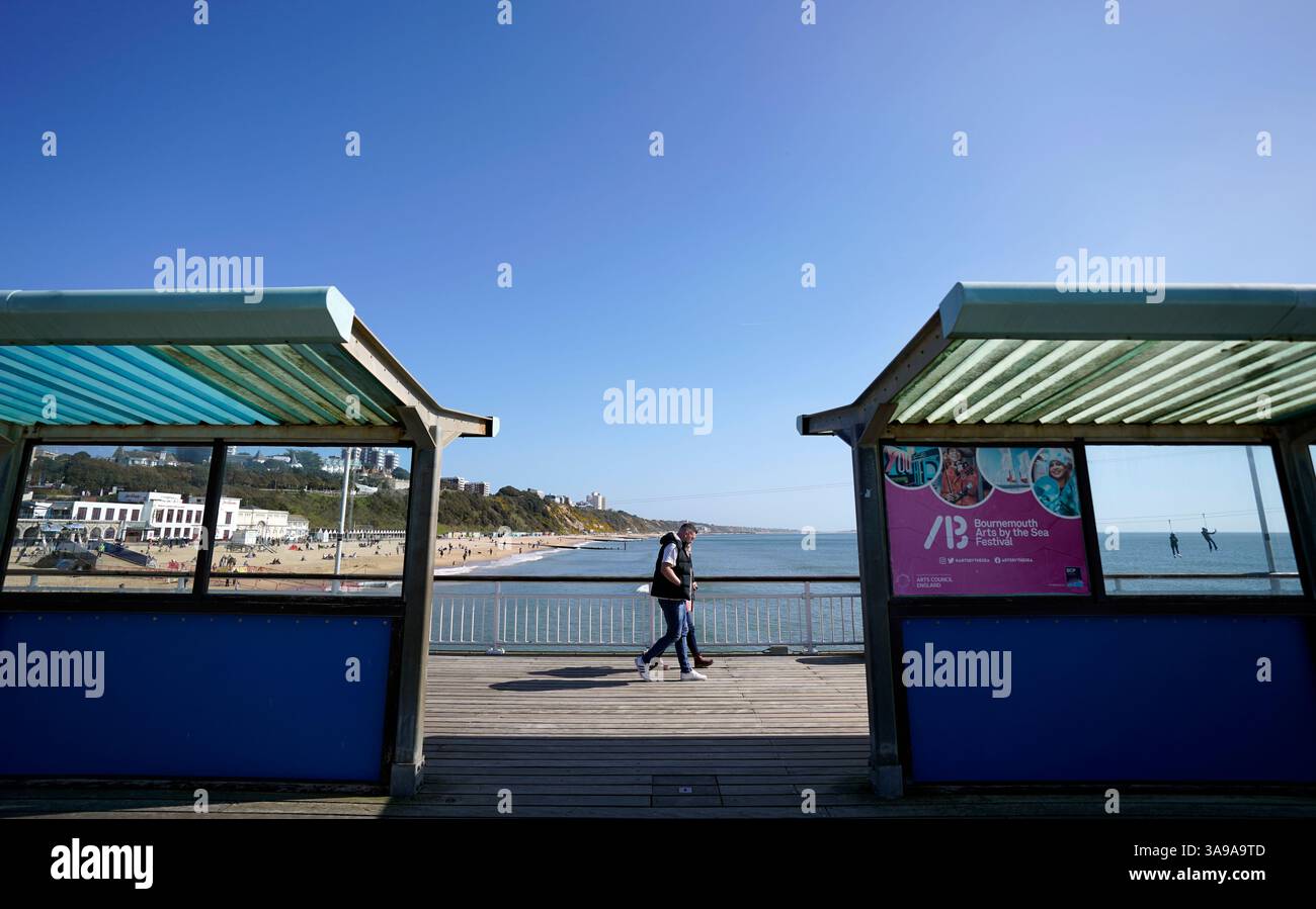 People walk along Bournemouth Pier in Dorset. Picture date: Sunday ...