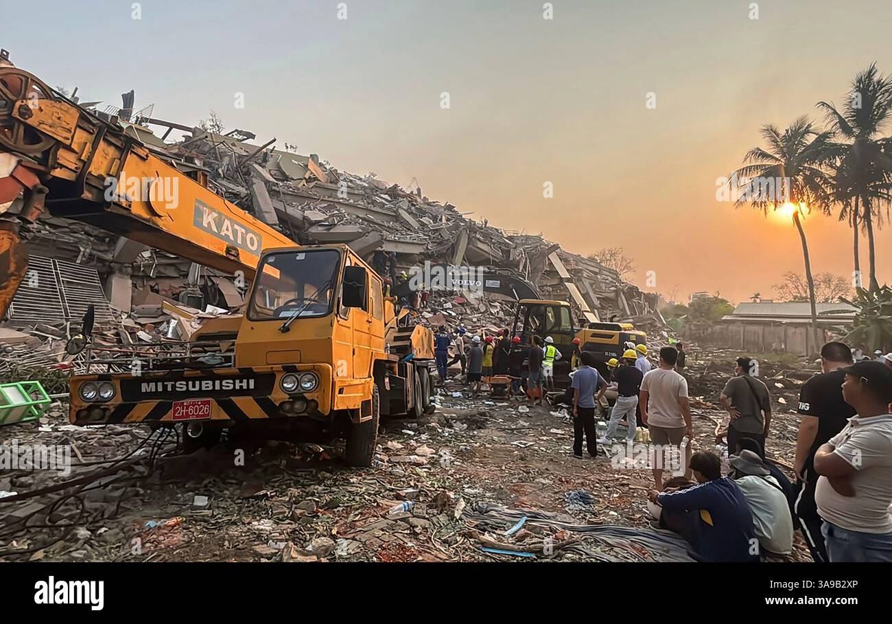 Rescuers work with the help of heavy machinery at the site of a ...