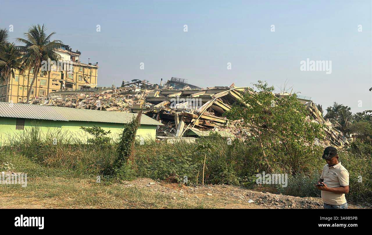 A man walks past the ruins of Sky Villa Condo that collapsed in Friday ...