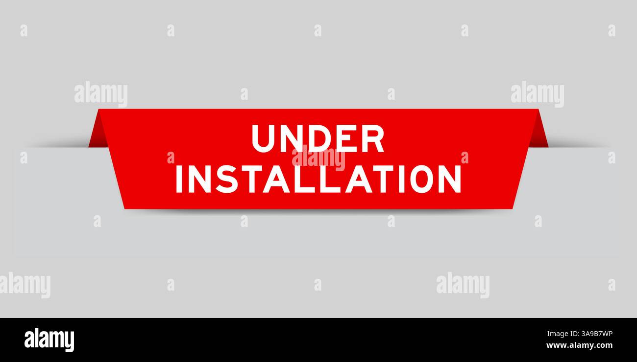 Red color inserted label with word under installation on gray ...