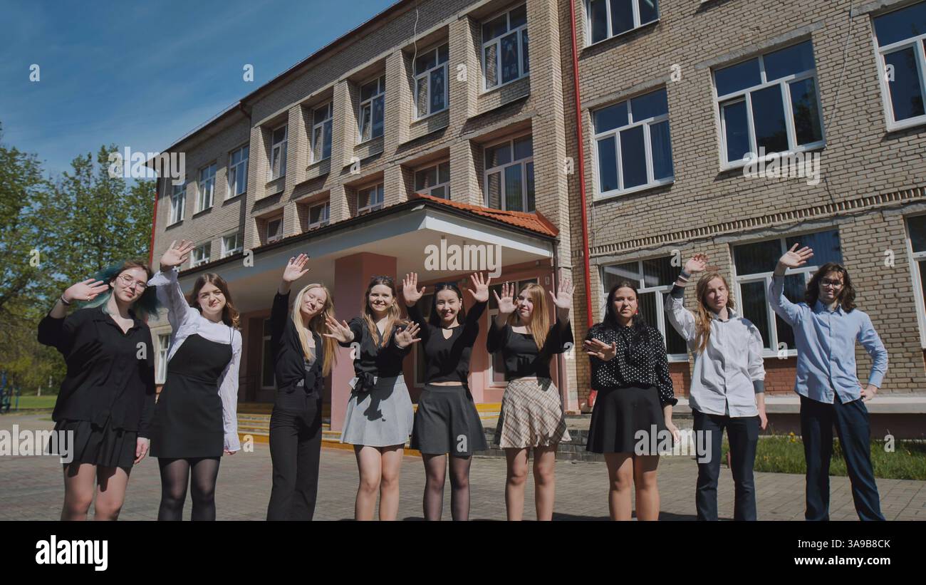 Happy high school students happily waving goodbye on their last sunny ...