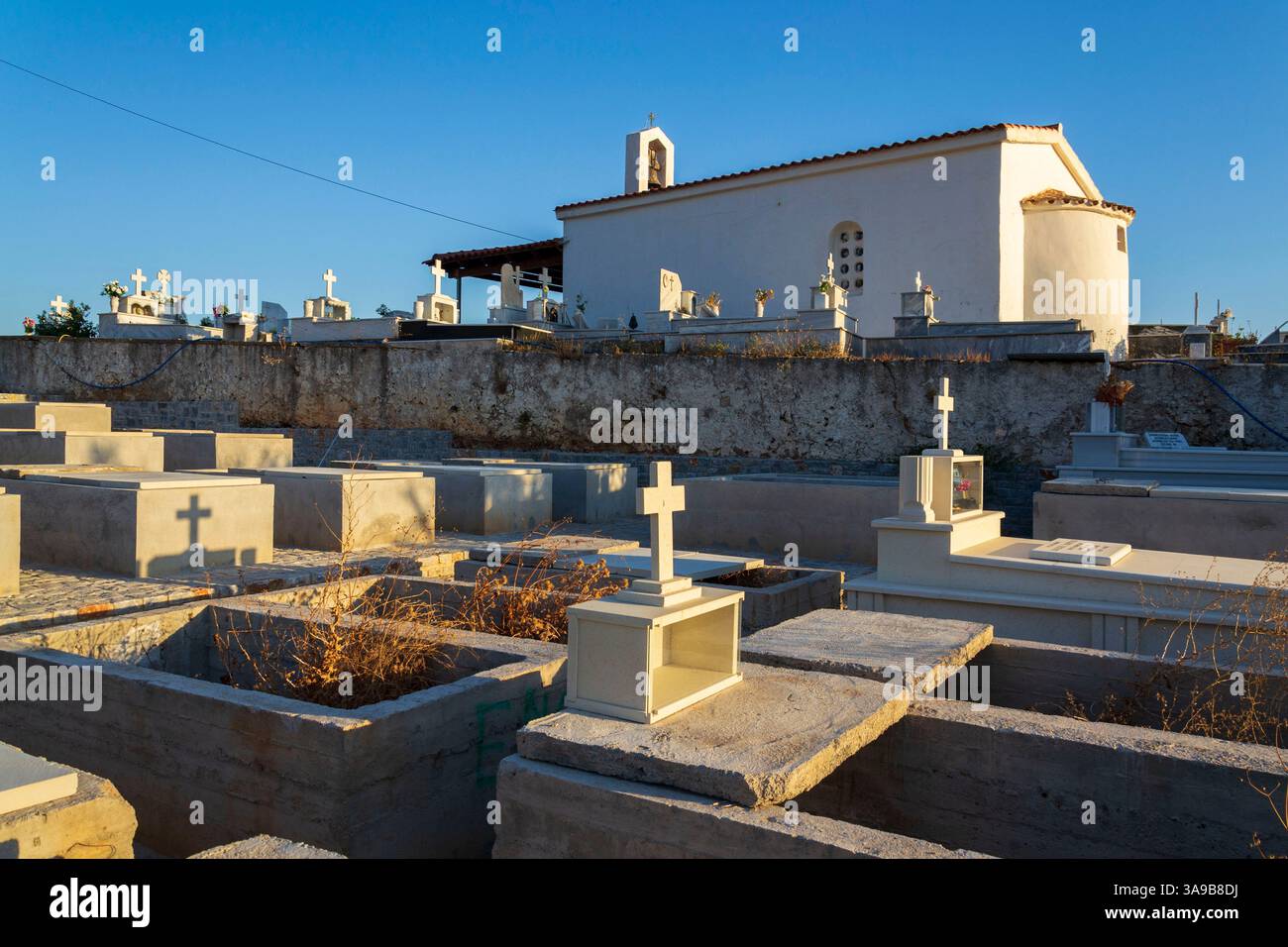 Chapel and crosses in a Greek cemetery at dawn, sunny summer day, Crete ...