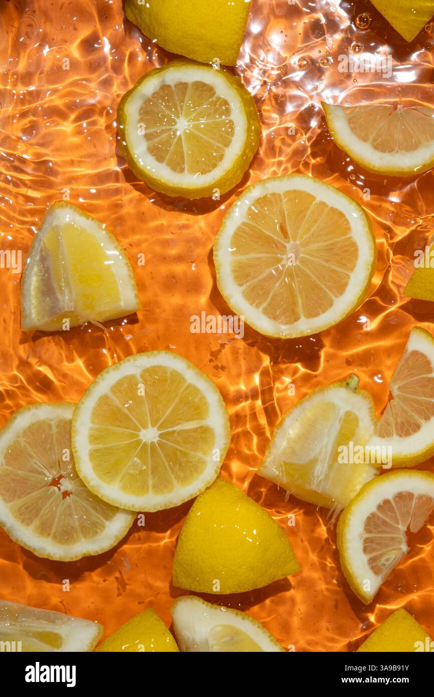 Juicy lemon background of halves and slices of fresh lemons in water ...