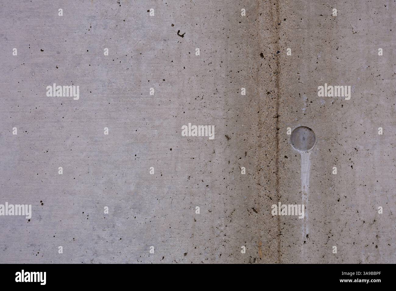 Concrete wall with subtle weathering and small rounded indentation ...