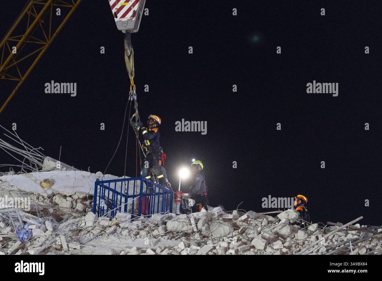 Rescuers work at the site of an under-construction high-rise building ...