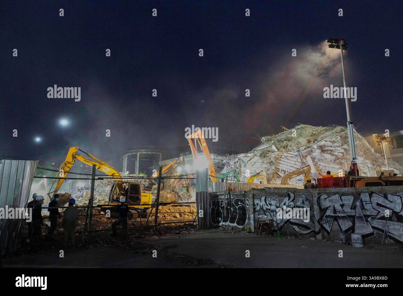 Rescuers work at the site of an under-construction high-rise building ...