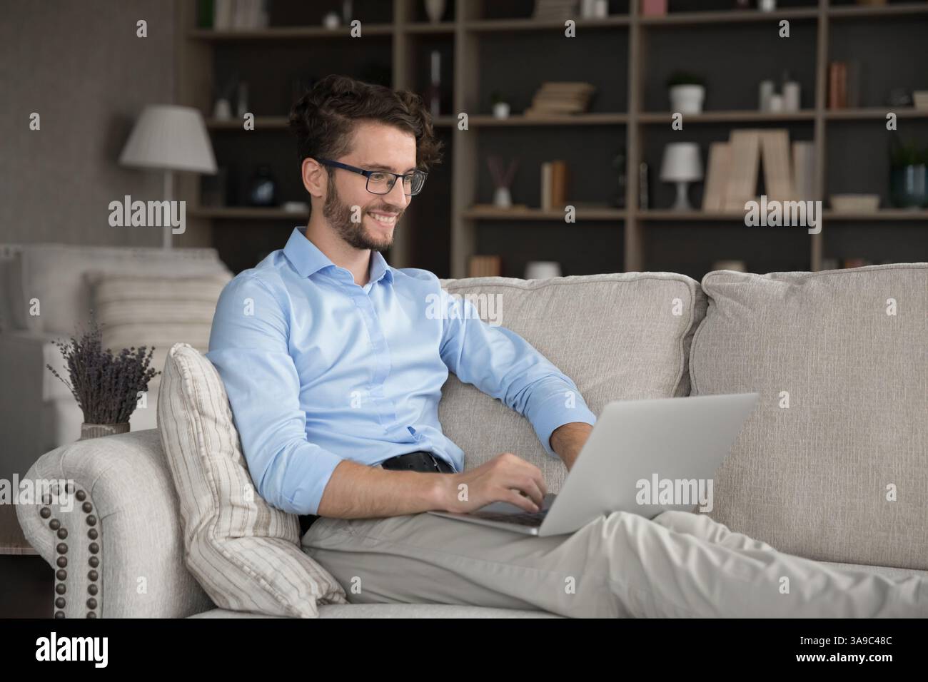 Happy smiling gen z male relax on couch using notebook Stock Photo - Alamy