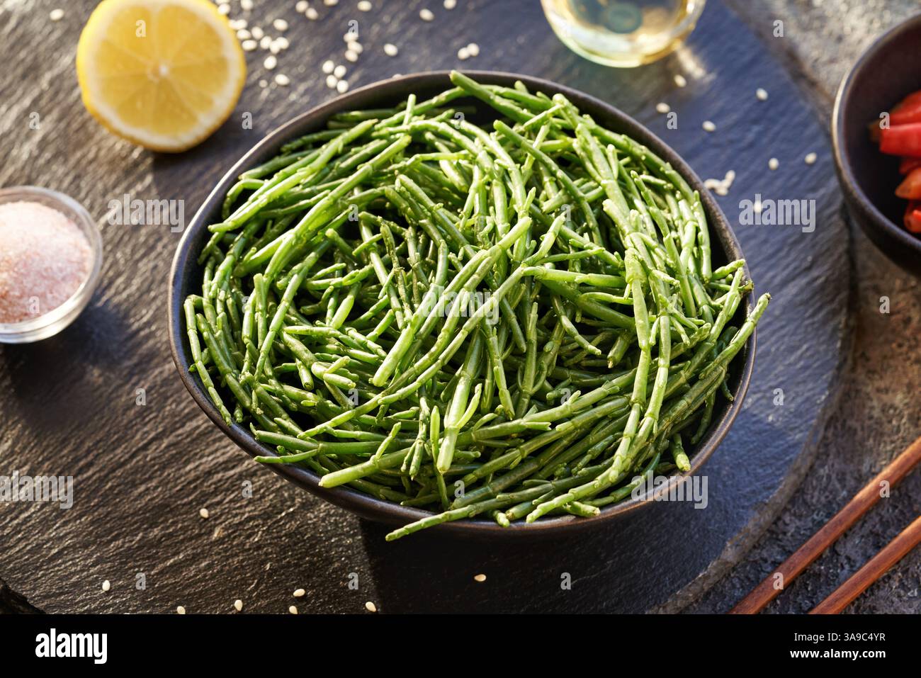 A bowl of fresh green Salicornia seaweed with lemon, sesame seeds ...