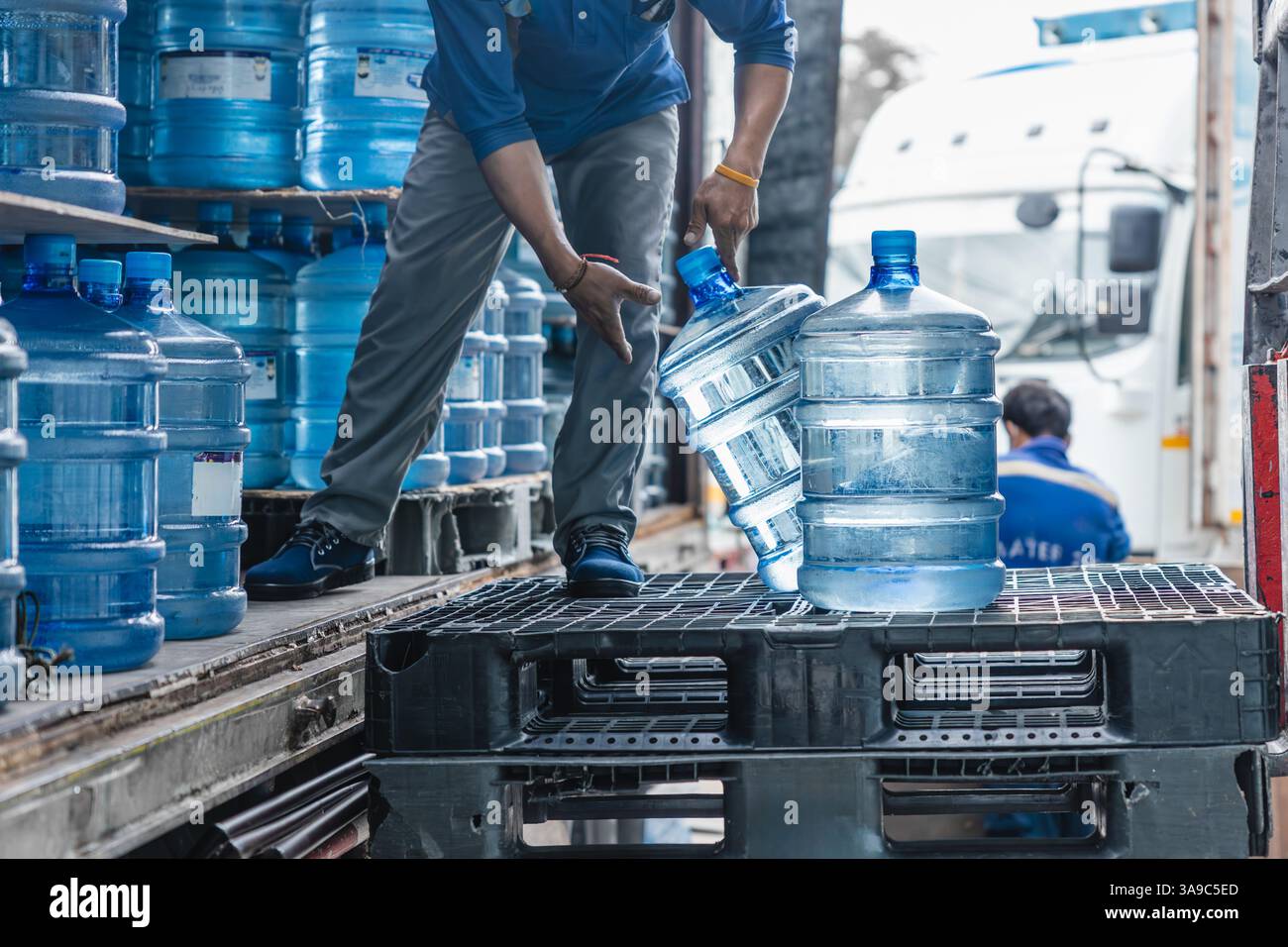 worker transfer drinking water bottle from production plant line to ...