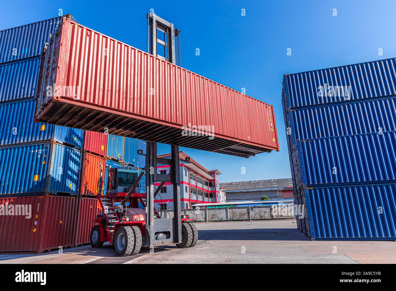 Truck forklift lifting loading heavy container cargo box at port container yard shipping ...