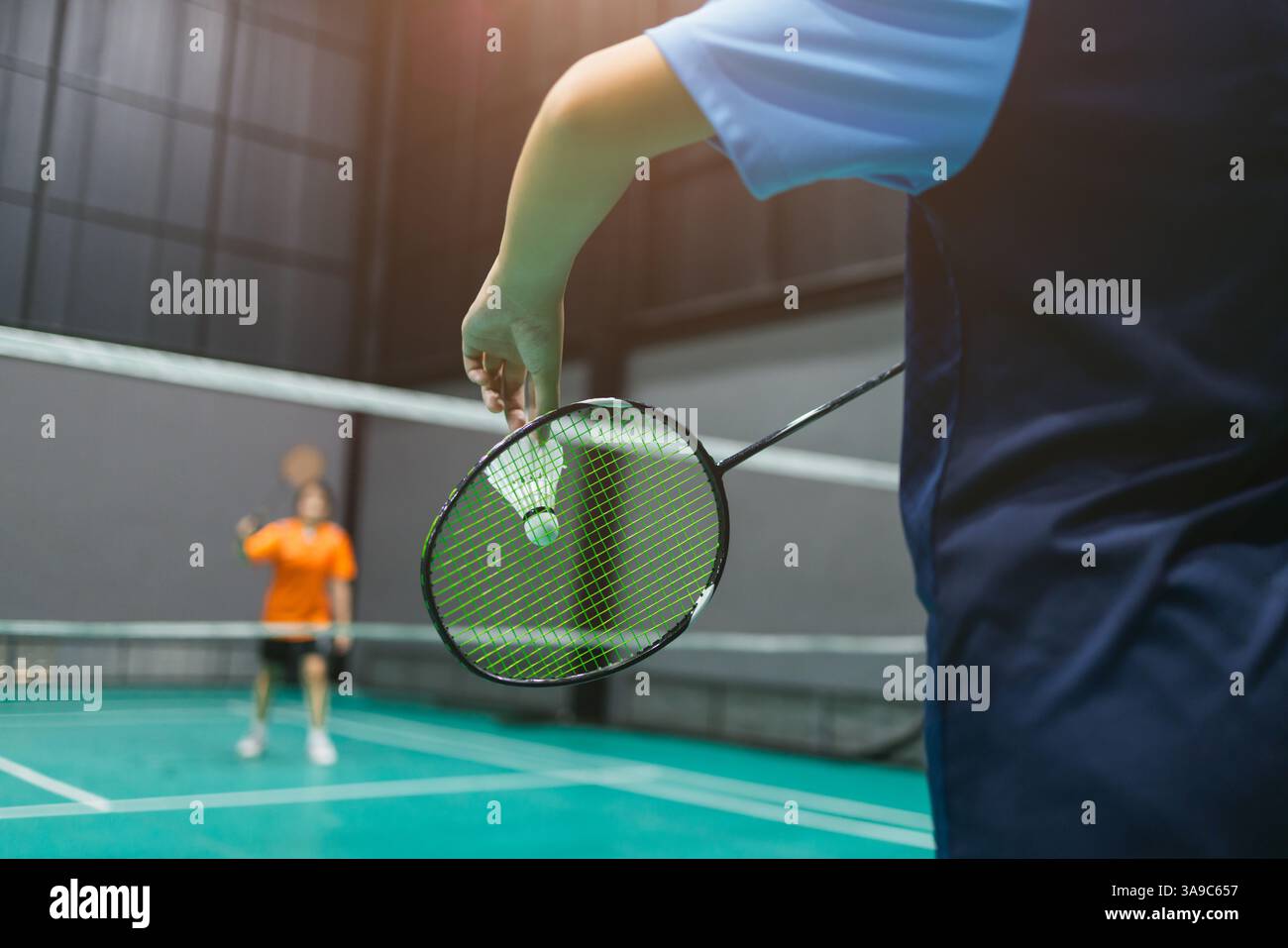 Badminton indoor sport player serving badminton shuttlecock with racket ...
