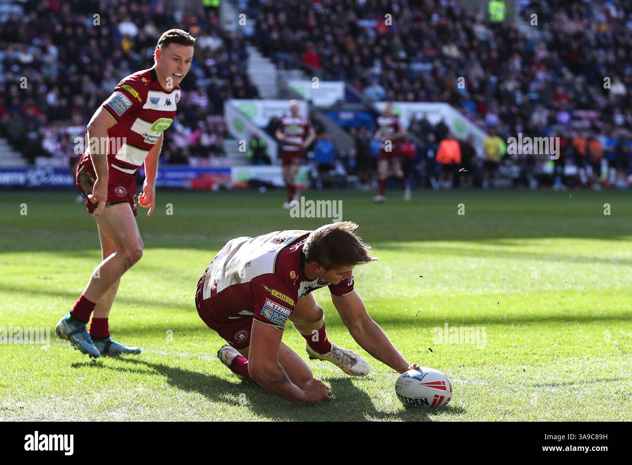Wigan, UK. 30th Mar, 2025. Sam Walters of Wigan Warriors goes over for ...