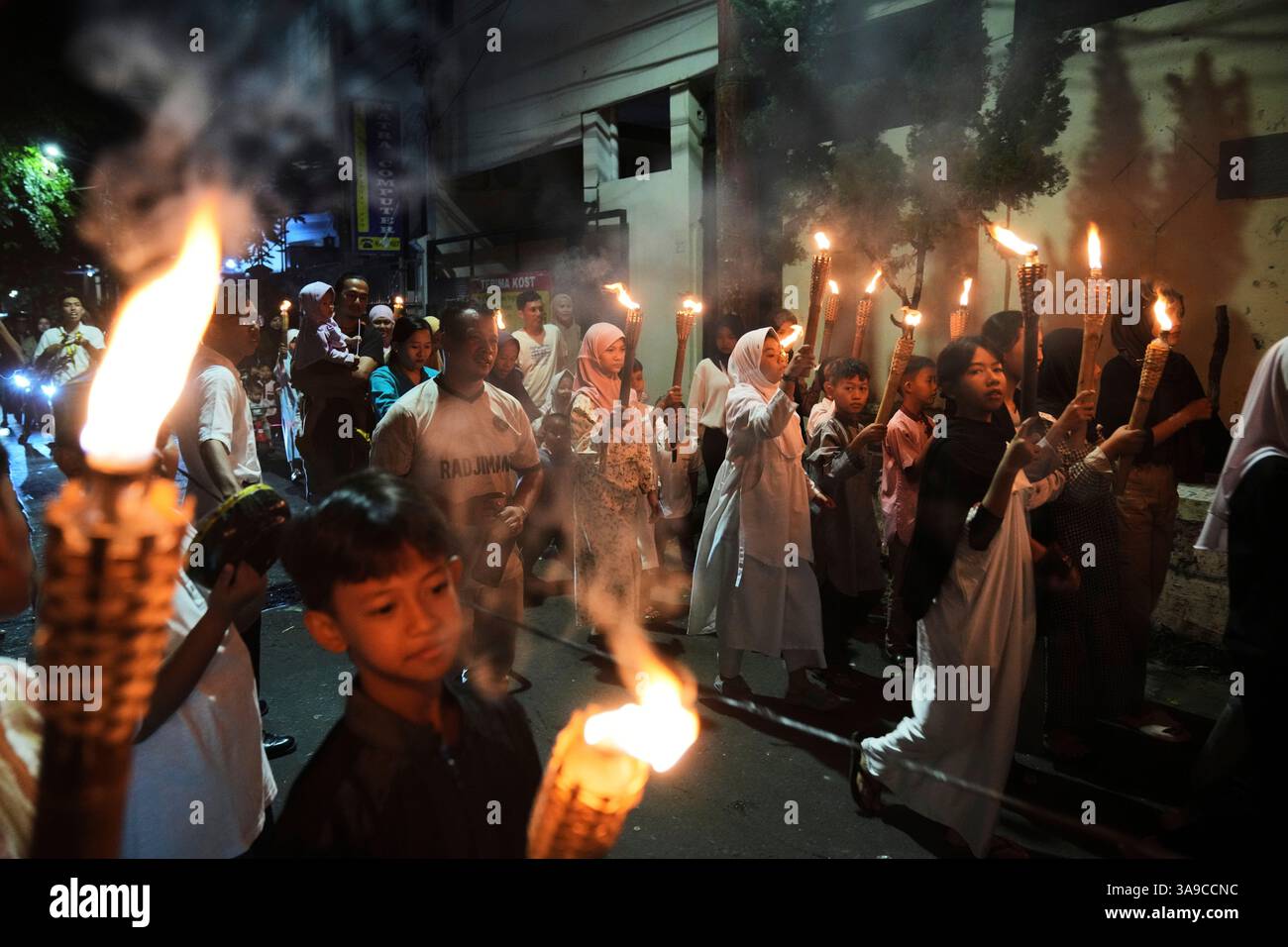 Children hold torches as they parade to celebrate the eve of Eid al ...