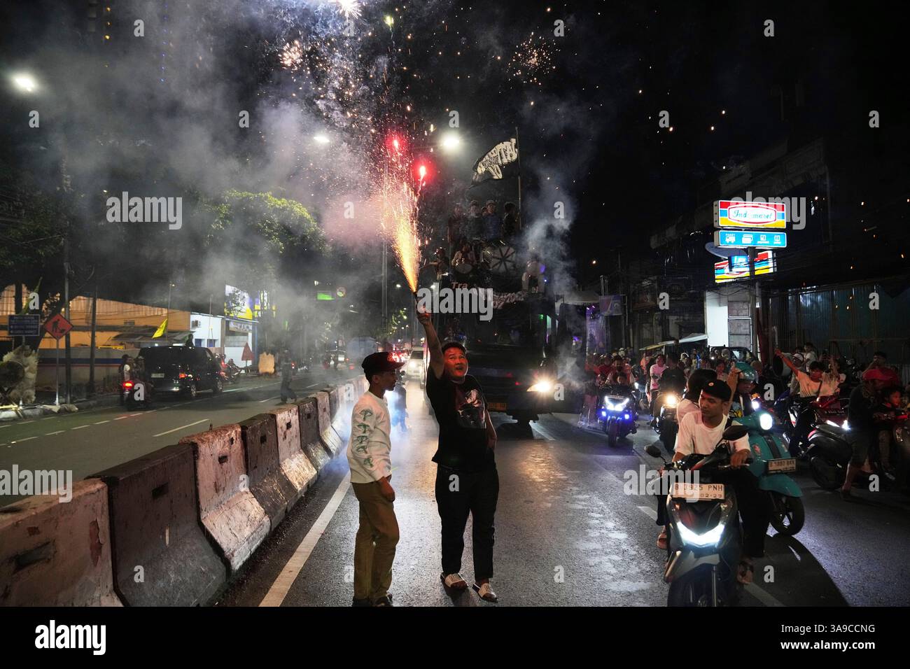 A man lights a firework during the celebration of the eve of Eid al ...