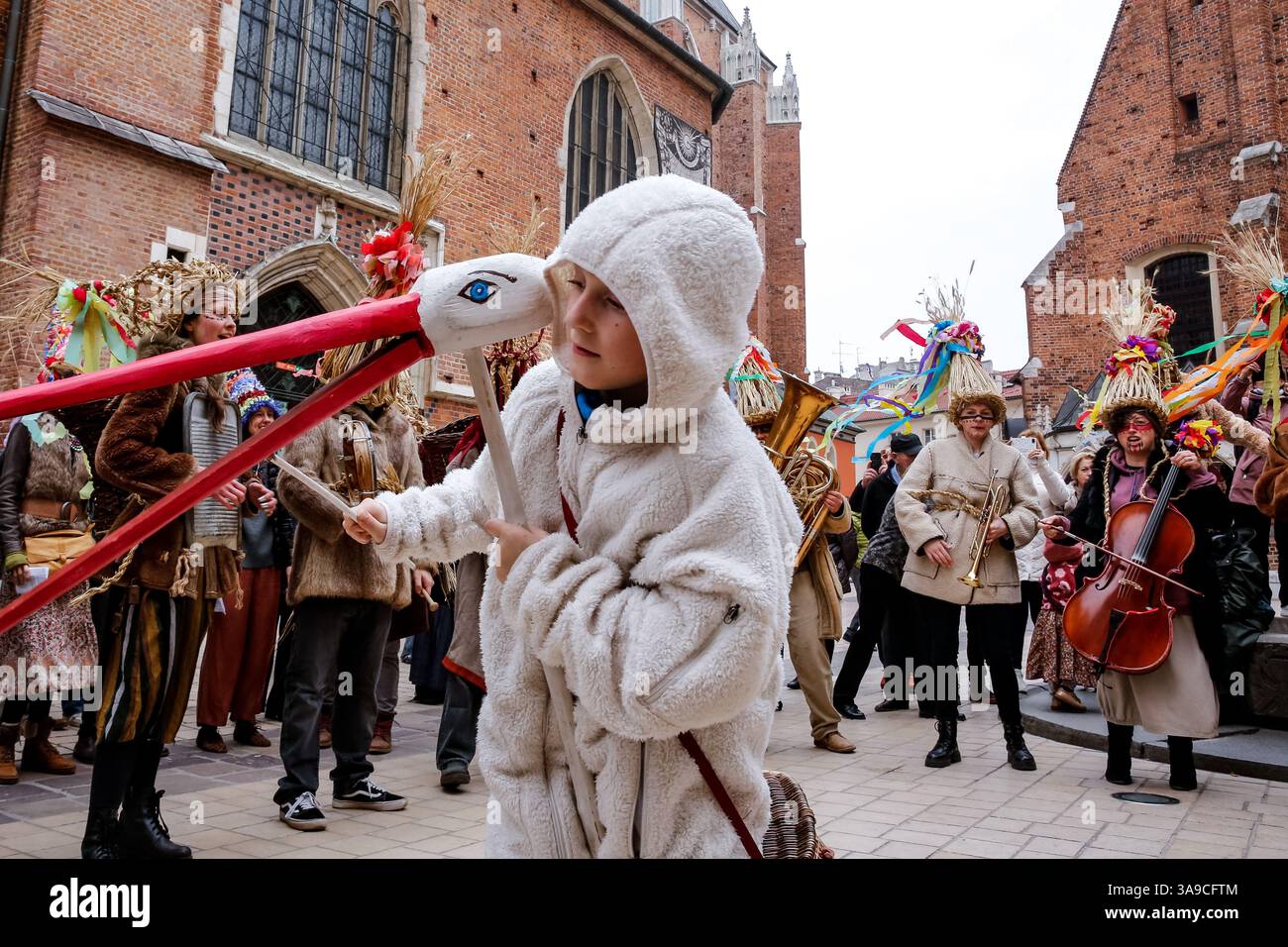 A boy plays with a folk toy as a group of musitians, dressed in a ...