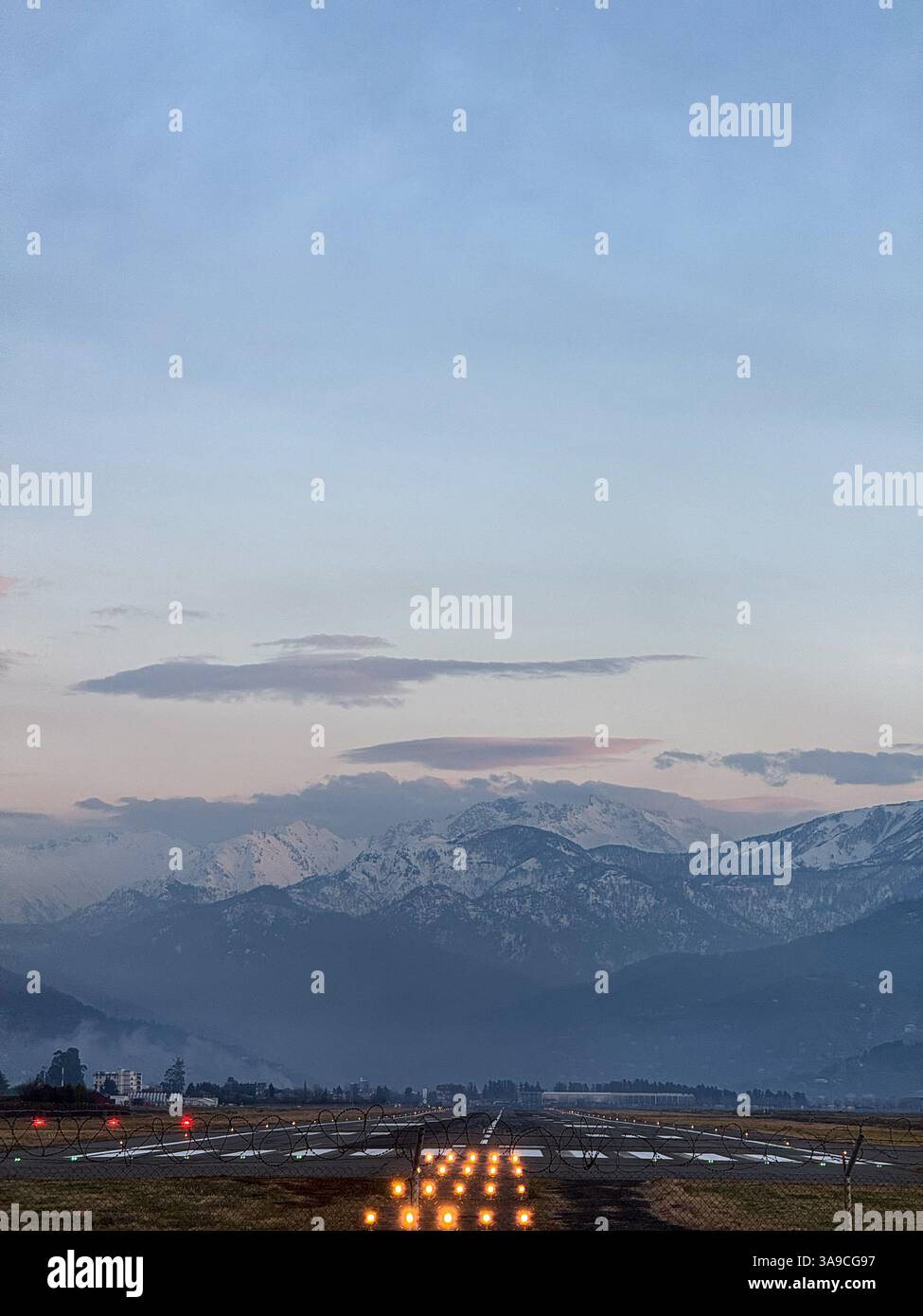 A runway with glowing lights stretches towards a stunning backdrop of ...