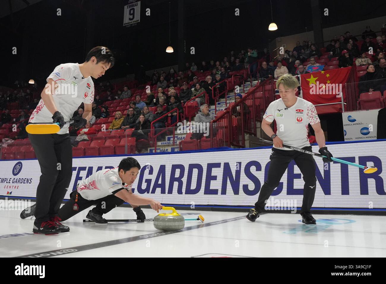 Japan's Shinto Usui throws a stone as Satoshi Koizumi (right) and Riki ...