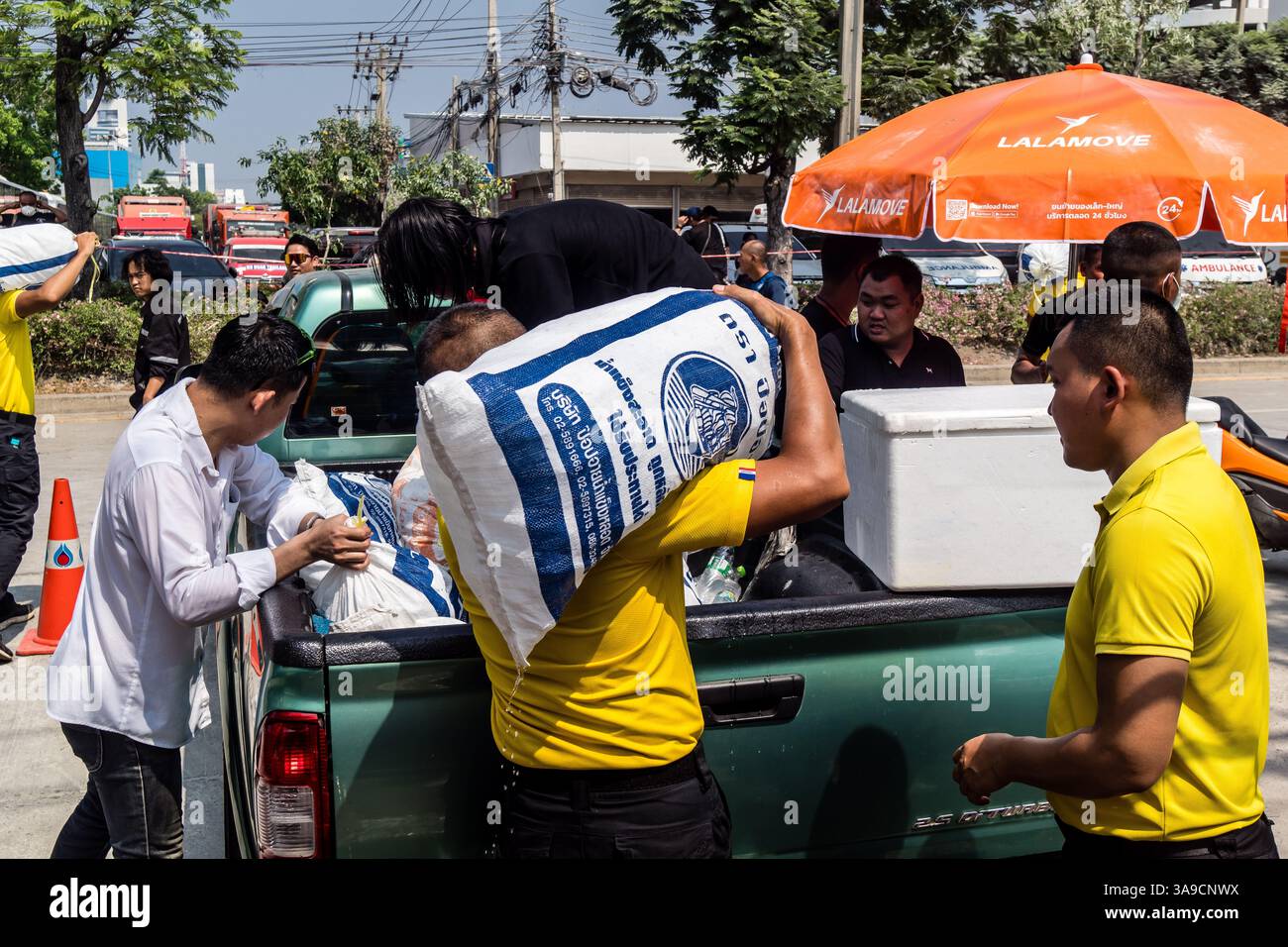 Bangkok, Thailand, March 29, 2025. Volunteers bring water and food to ...