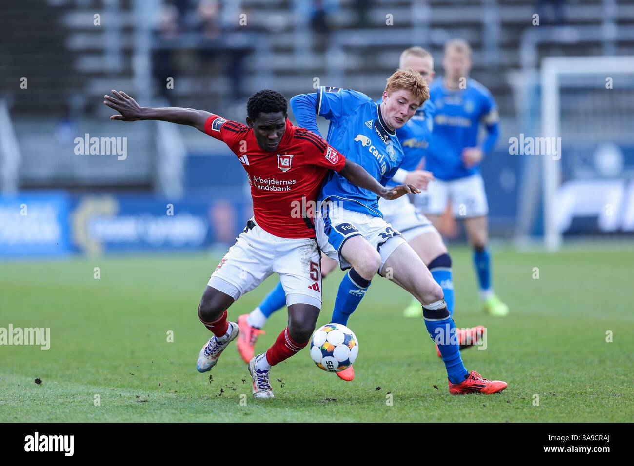 Lyngby, Denmark. 30th Mar, 2025. Hamza Barry (5) of Vejle BK and Peter ...