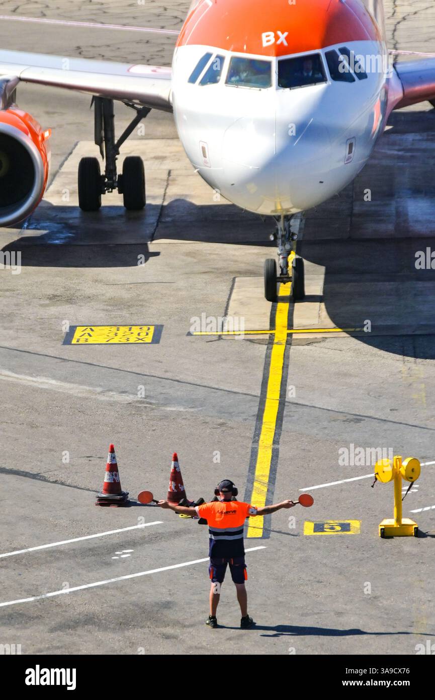 Luqa, Malta - 9 August 2023: Airport ground crew member marshalling an ...